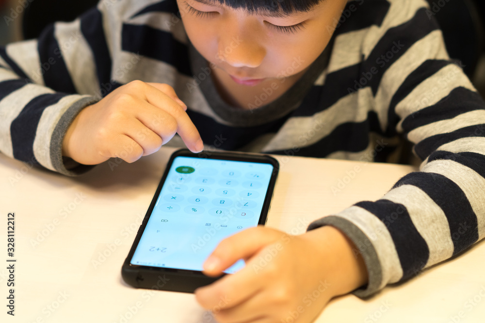 Young cute Asian boy use calculator app in smartphone to calculate ...