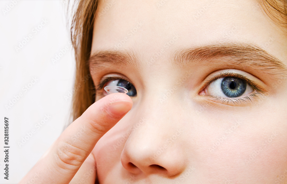 Little girl child putting contact lens into her eye Stock Photo | Adobe ...