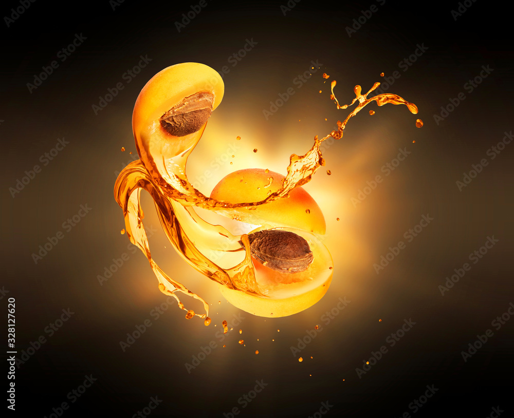 Juice splashes out from the cut apricot with flash of light in the dark ...