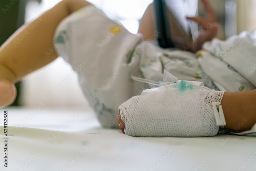 Child or girl patient rest on bed and hand still lock with equipment ...