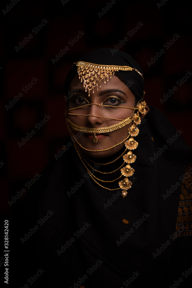 Conceptual middle eastern face portrait of a woman adorned with golden ...