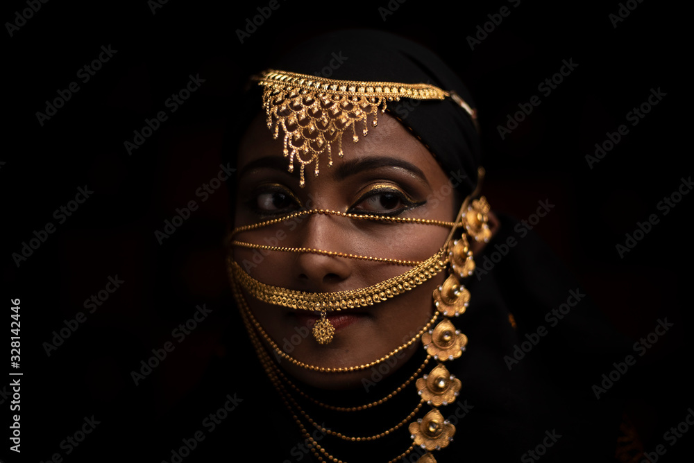 Conceptual middle eastern face portrait of a woman adorned with golden ...