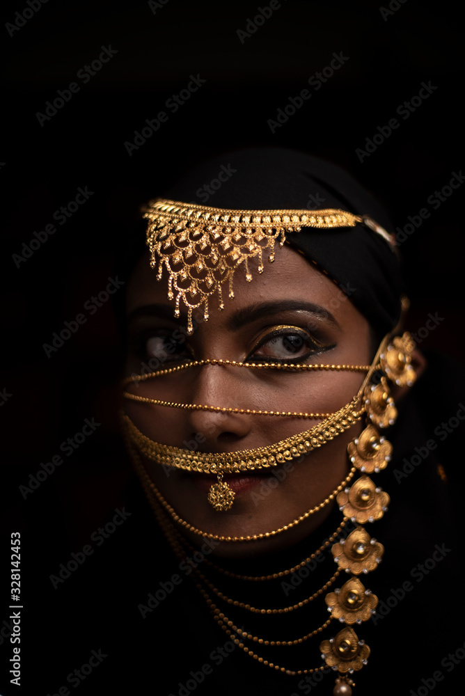 Conceptual middle eastern face portrait of a woman adorned with golden ...