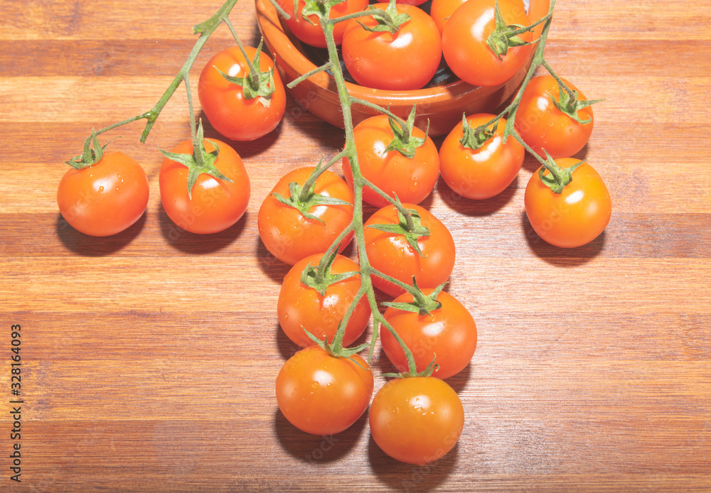 tomates cherry en rama recien recogidos en mader y vasija de barro ...