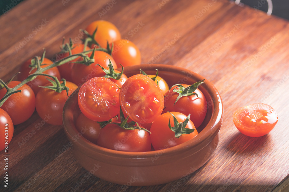 tomates cherry en rama recien recogidos en mader y vasija de barro ...