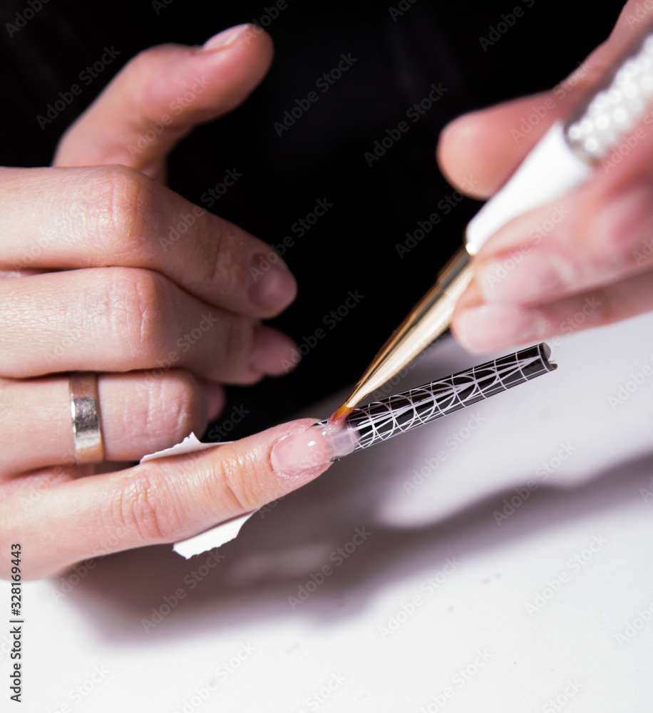 Extension of nails on the form using a disposable stencil sticks Stock ...