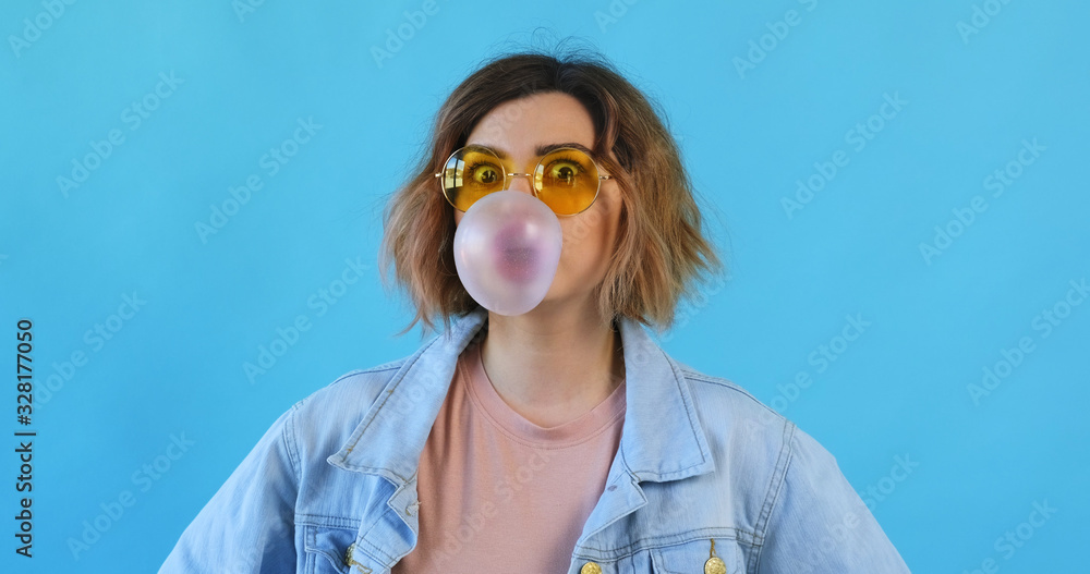 Portrait happy smile woman in star sunglasses inflates bubble from ...