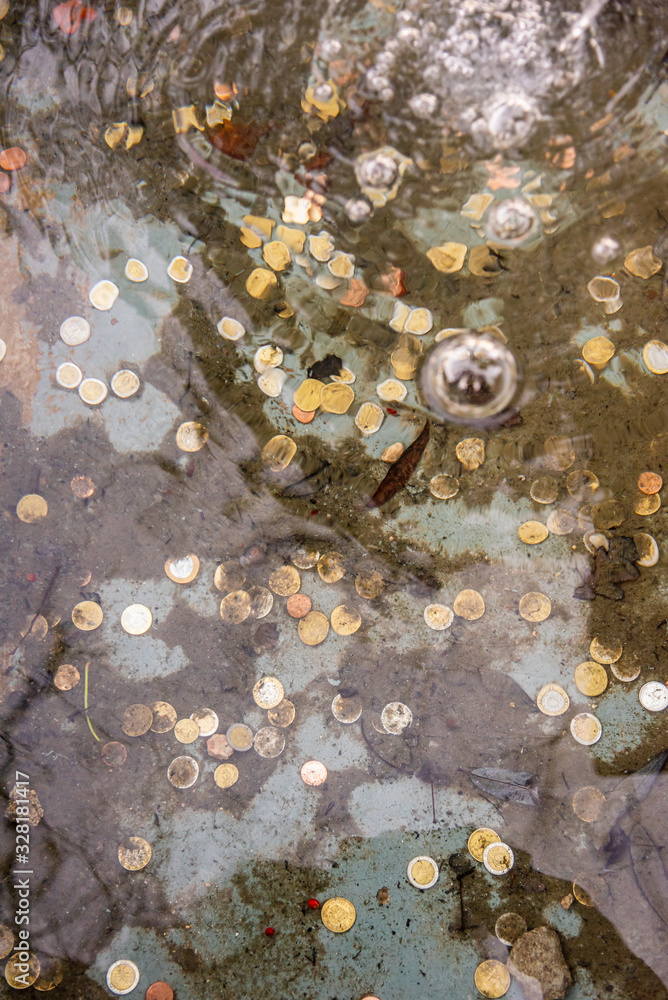 Coins at the bottom of a fountain seen through the magnification of the ...