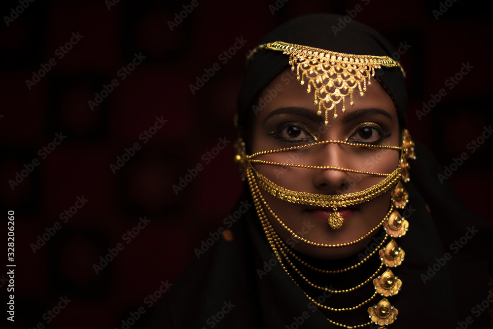 Conceptual middle eastern face portrait of a woman adorned with golden ...