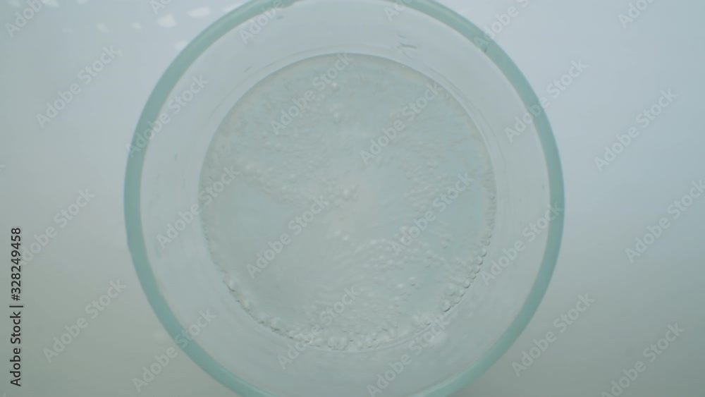 Zoom in top view shot of hand throwing effervescent tablet into glass ...