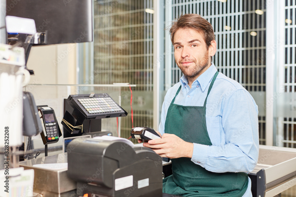Cashier with apron at the cash register Stock Photo | Adobe Stock