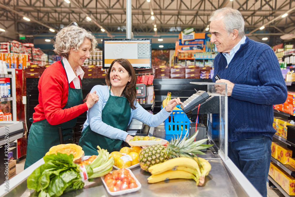 Saleswoman helps trainee at the supermarket cashier Stock Photo | Adobe ...