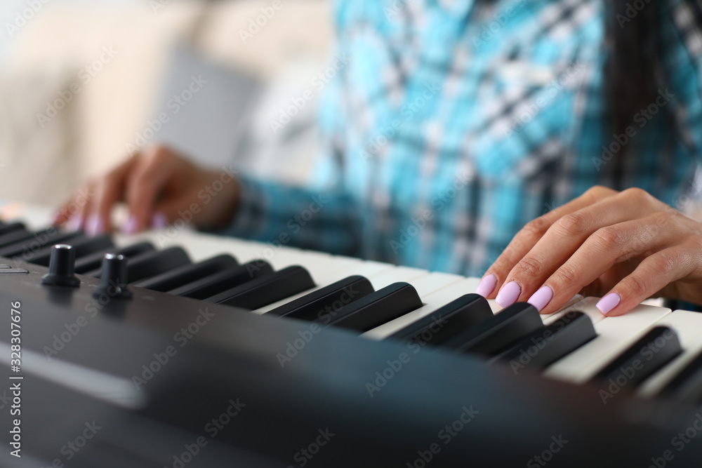 Musician fingers on flat keys synthesizer surface. Girl gets used to ...