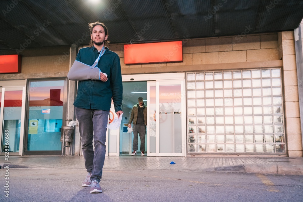 Man coming out of a hospital with his hand in a cast Stock Photo ...