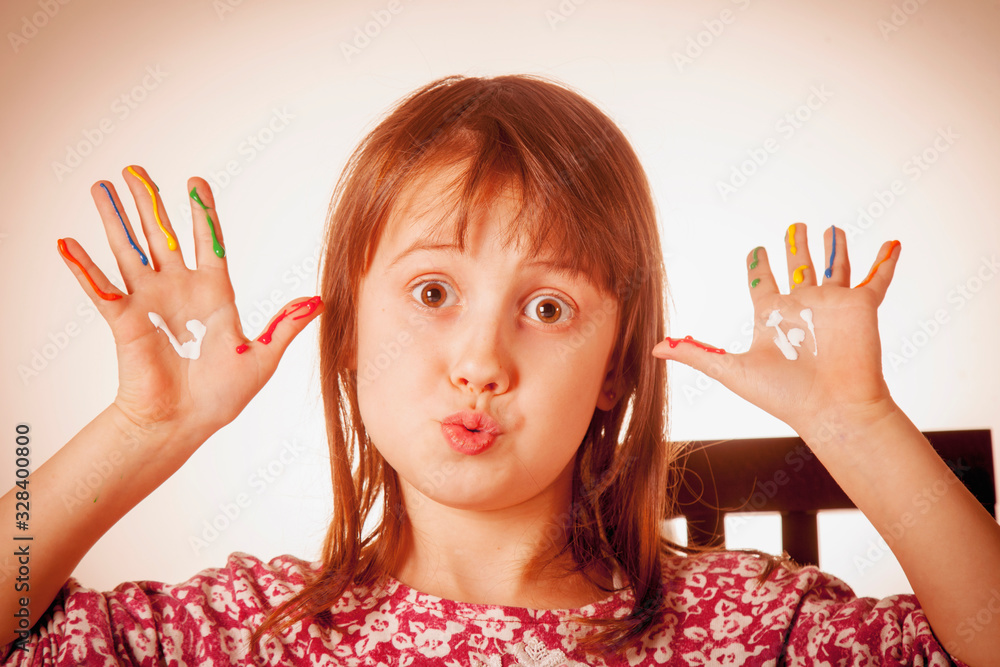 Little cute child girl showing painted hands. Funny facial expression ...