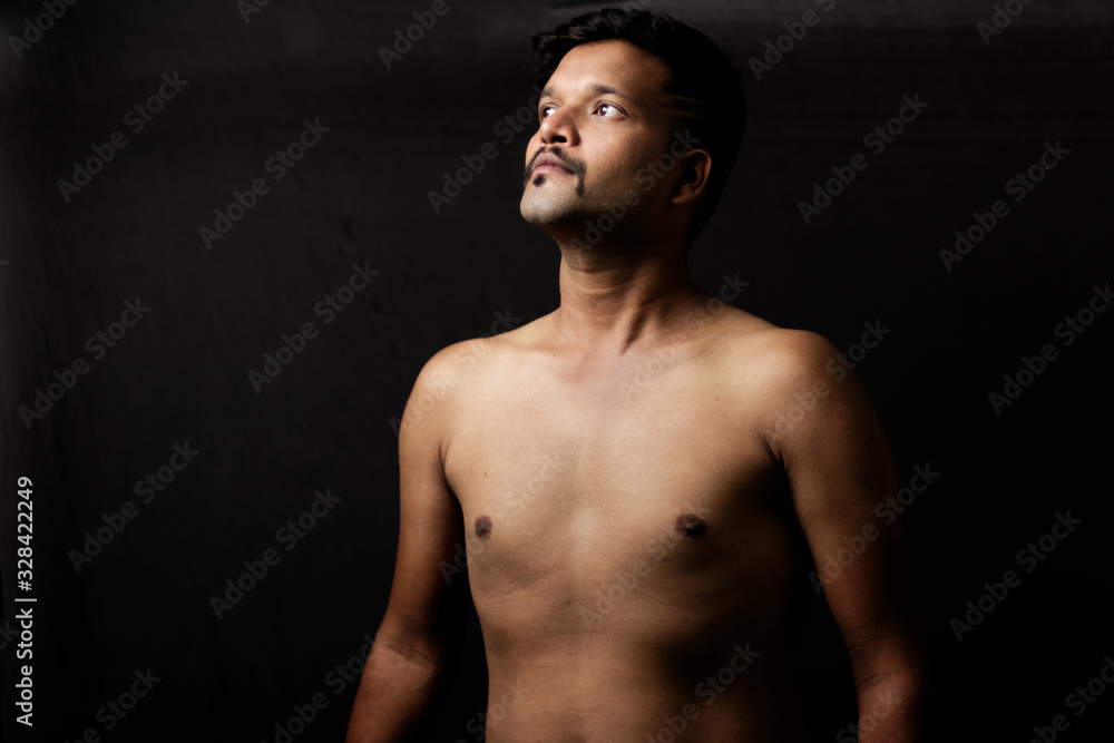 Portrait of a confident muscular Indian brunette dark skinned macho man ...