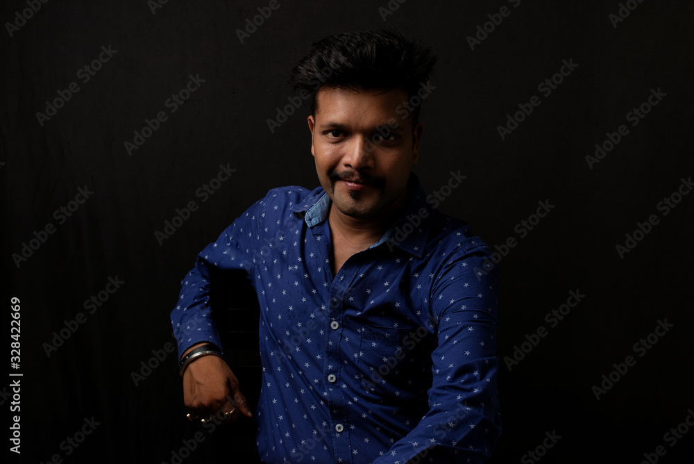 Portrait of a handsome and intelligent Indian brunette man wearing blue ...