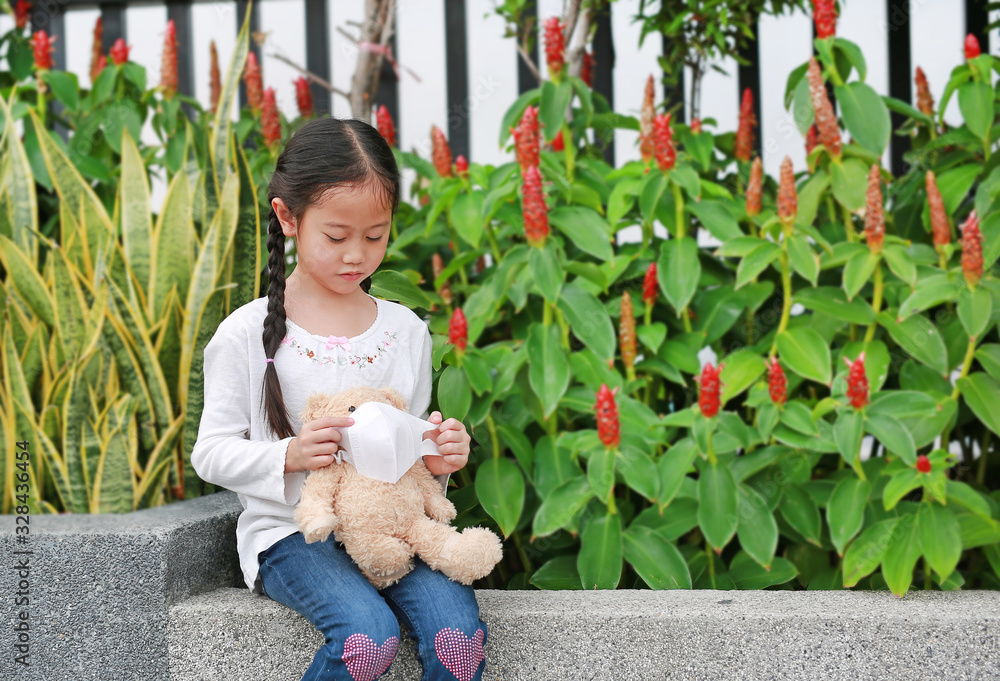 Asian little kid girl wearing mask for teddy bear doll to protect ...
