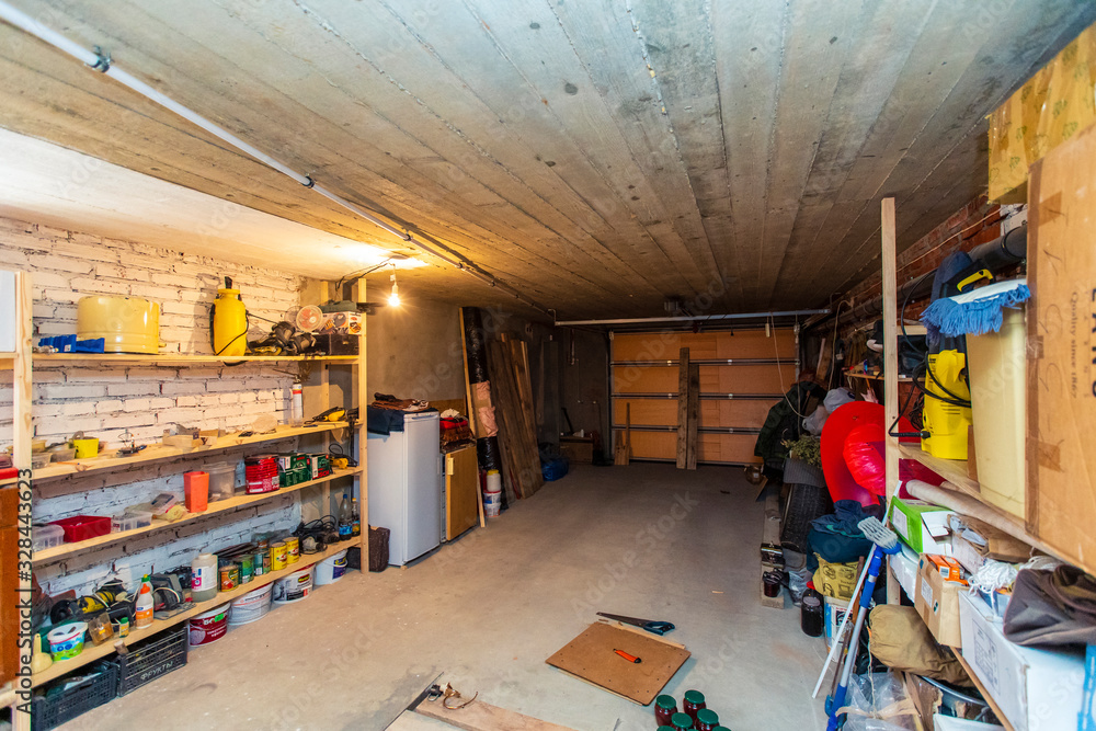 Garage in the basement of the cottage. Shelves with cans, boxes, and ...