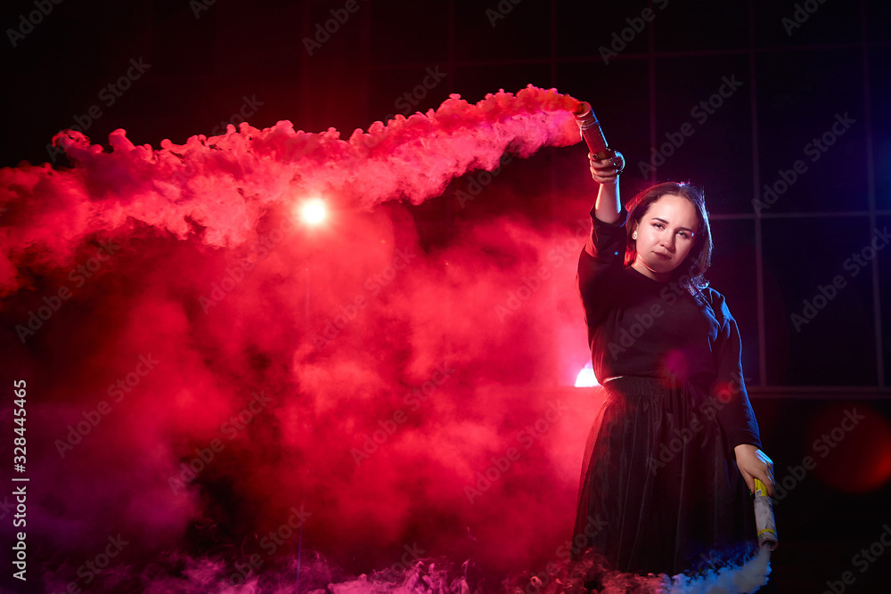 Teenage chubby girl with colored smoke torch in hand during photoshoot ...