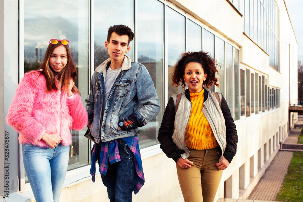 cute group of teenages at the building of university with books ...