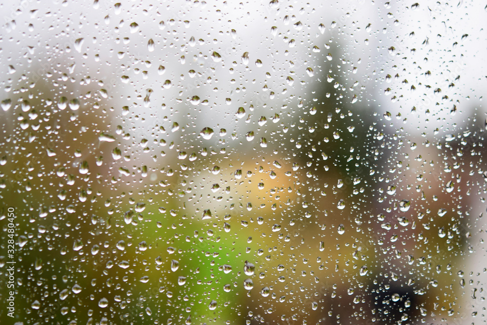 Abstract blurred of water drops or raindrops on the glass of window ...