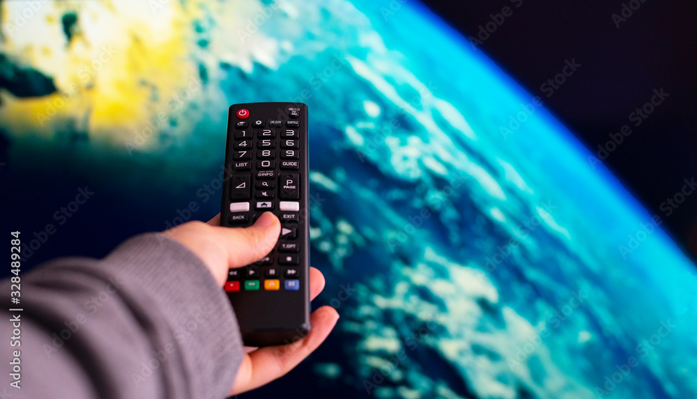 Hand with tv remote control with the TV with the space in the ...