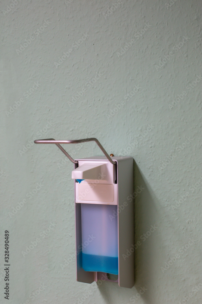 dispenser with a bottle of medical disinfectant hanging on a wall Stock ...