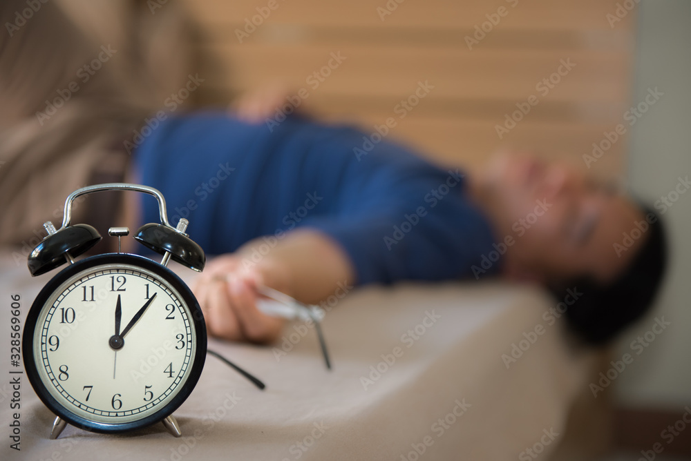 Time to sleep, Alarm clock on the bed with young man sleeping on the ...