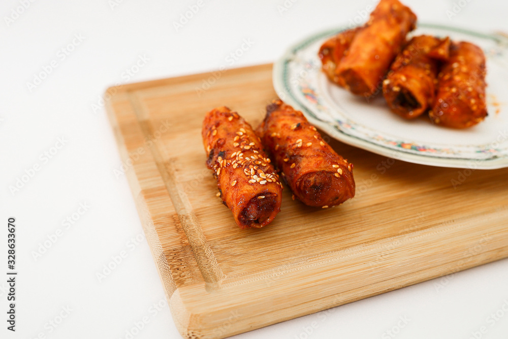 A close view of two sweet and spicy fried spring rolls. Placed on a ...