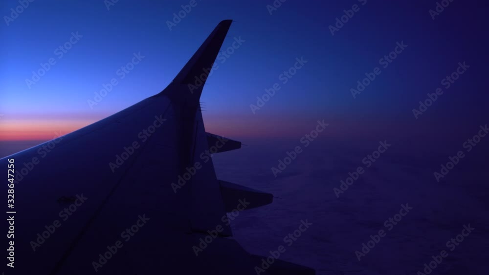 Through the porthole, you can see the wings of the aircraft , which is ...