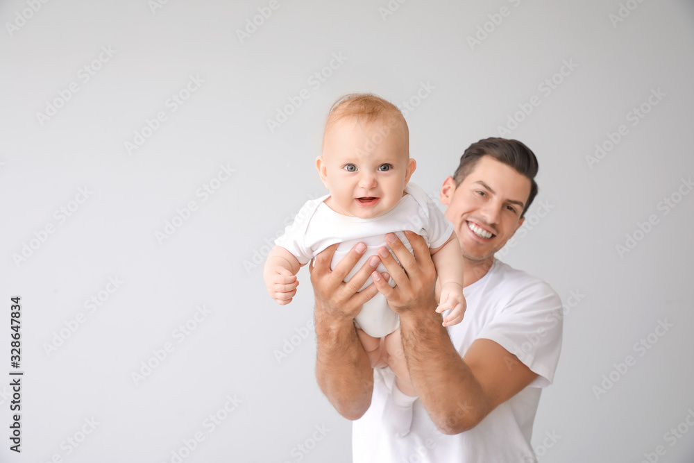 Cute baby with father on light background Stock Photo | Adobe Stock