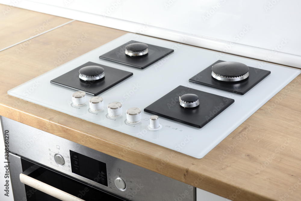 Burners on a white glass gas stove in the kitchen. Top view. Hob ...