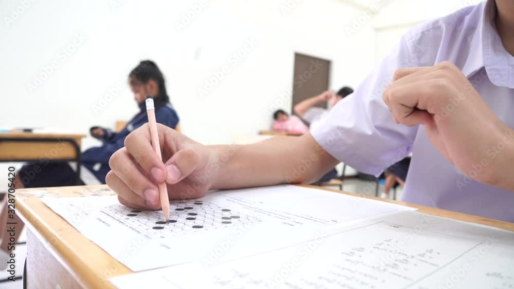 Exam classroom of students group hands holding fill in carbon paper ...