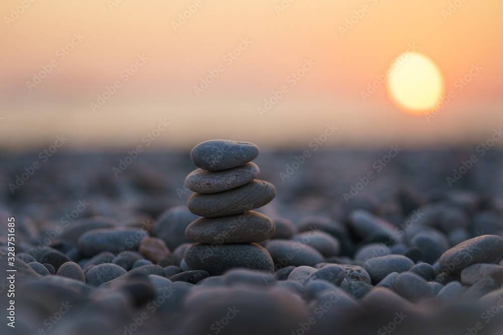 Balanced stone pyramid on pabbles beach with sunset. Zen rock, concept ...