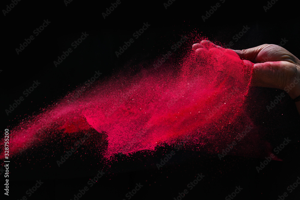 Closeup hand red colour holi powder splash at black background, red ...