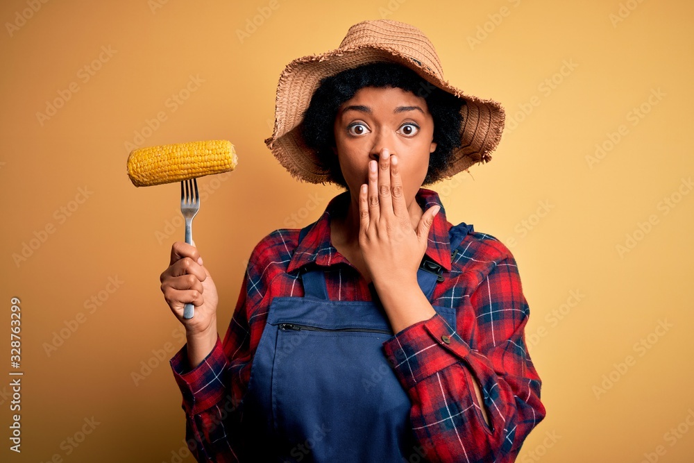 Young African American afro farmer woman with curly hair wearing apron ...