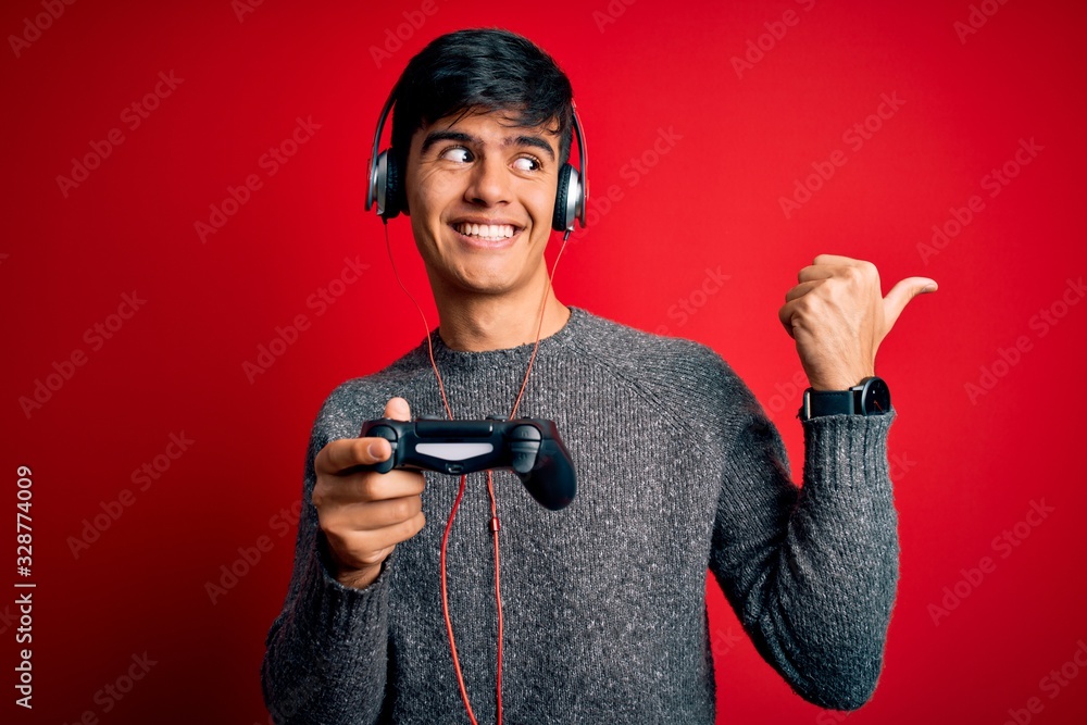 Young handsome gamer man playing video game using joystick and ...