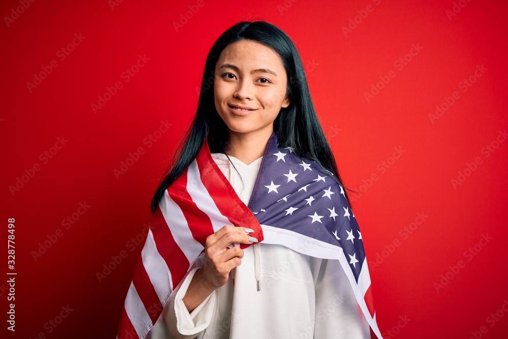 Young beautiful chinese woman wearing United States flag over isolated ...