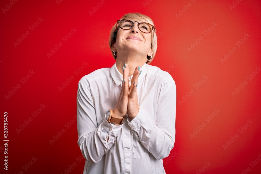 Young blonde business woman with short hair wearing glasses over red ...