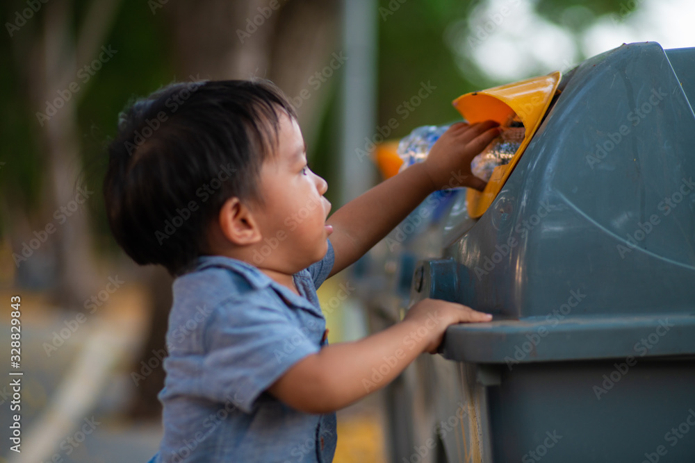 Little asian toddler baby boy throwing plastic bottle in recycling ...
