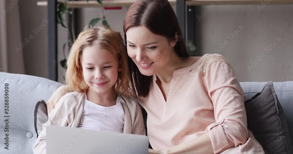 Excited young mother and kid girl look at laptop computer screen feel ...