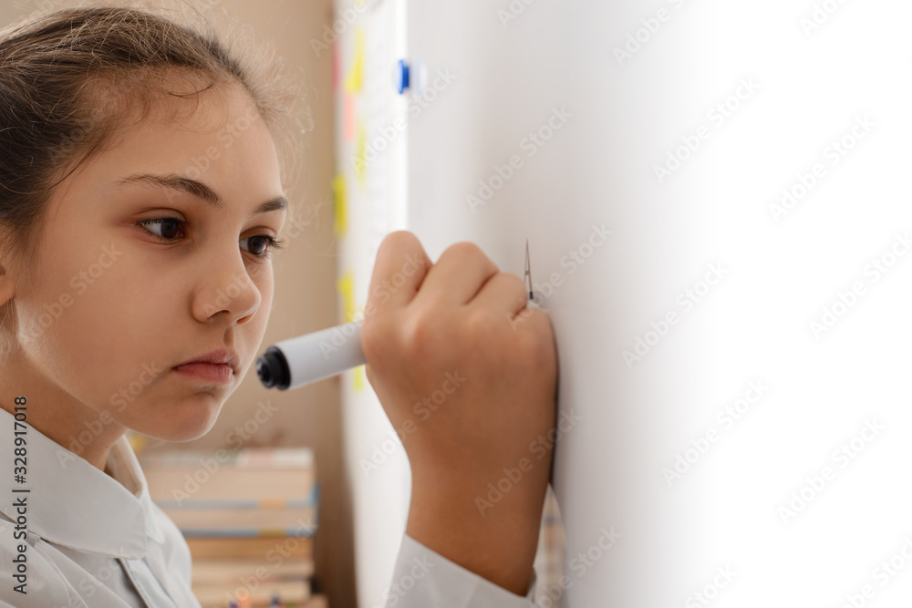 Concentrated female learner of secondary school writing some task on ...