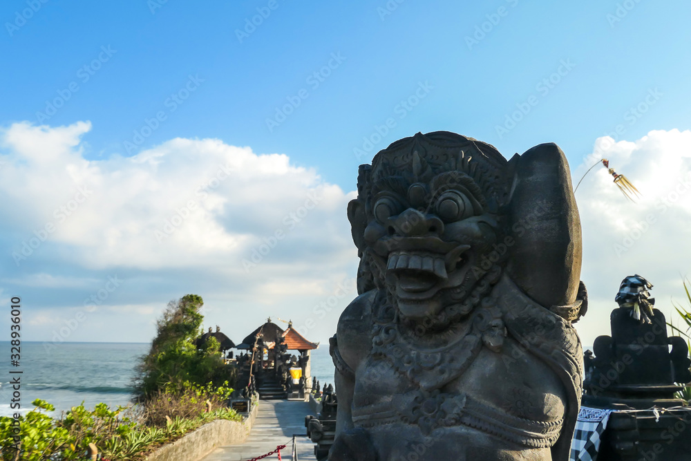 A guardian God at the promenade to a small temple in Tanah Lot temple ...