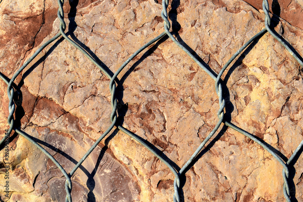 Blocks of stone behind a wire mesh. Protection from collapses. Stone ...