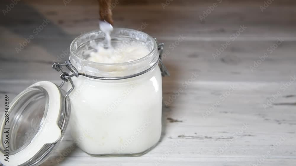 Close up of fresh homemade fermented beverage kefir in a jar, a female ...