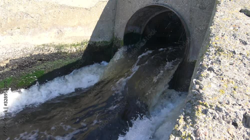 Water pollution. Dirty water from treatment plants flows through a pipe ...