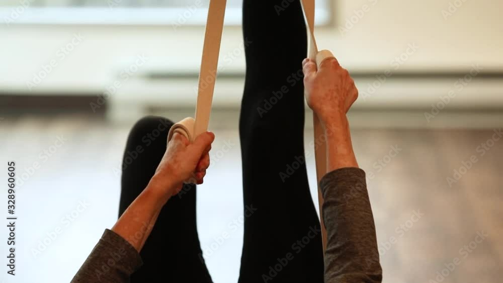 Female leg exercising using resisting loop band while practice chair ...