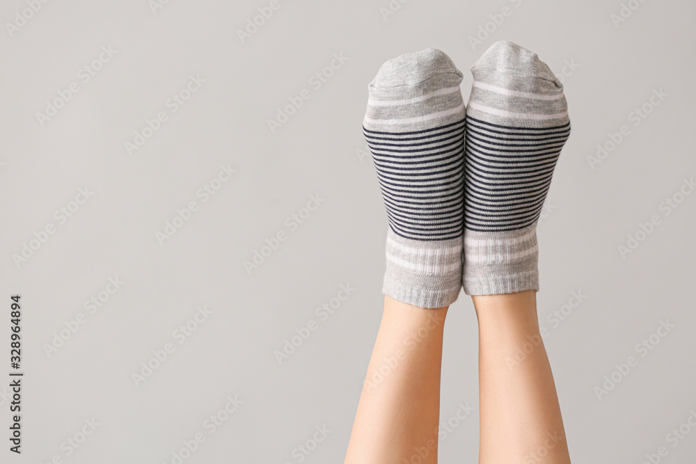 Legs of woman in socks on grey background Stock Photo | Adobe Stock