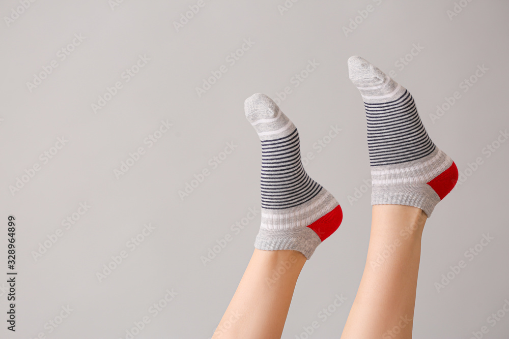 Legs of woman in socks on grey background Stock Photo | Adobe Stock